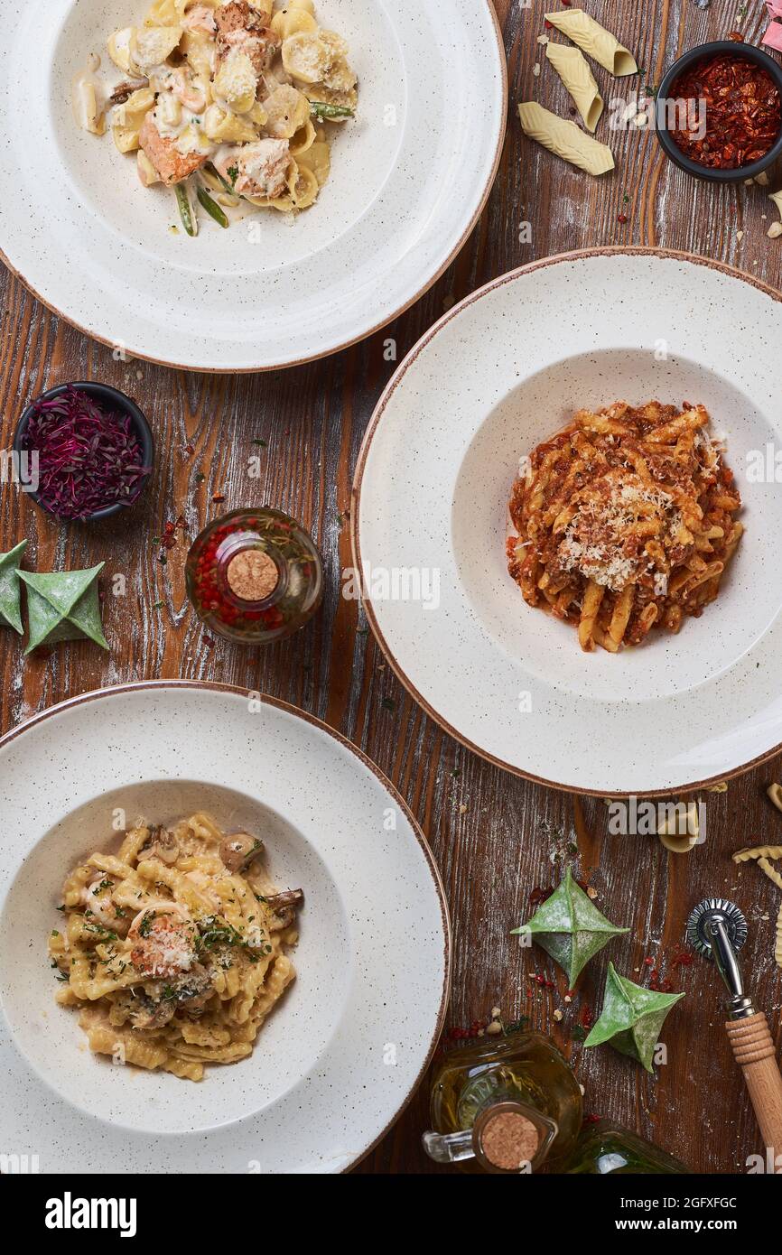 three types of Italian pasta on a wooden table Stock Photo - Alamy