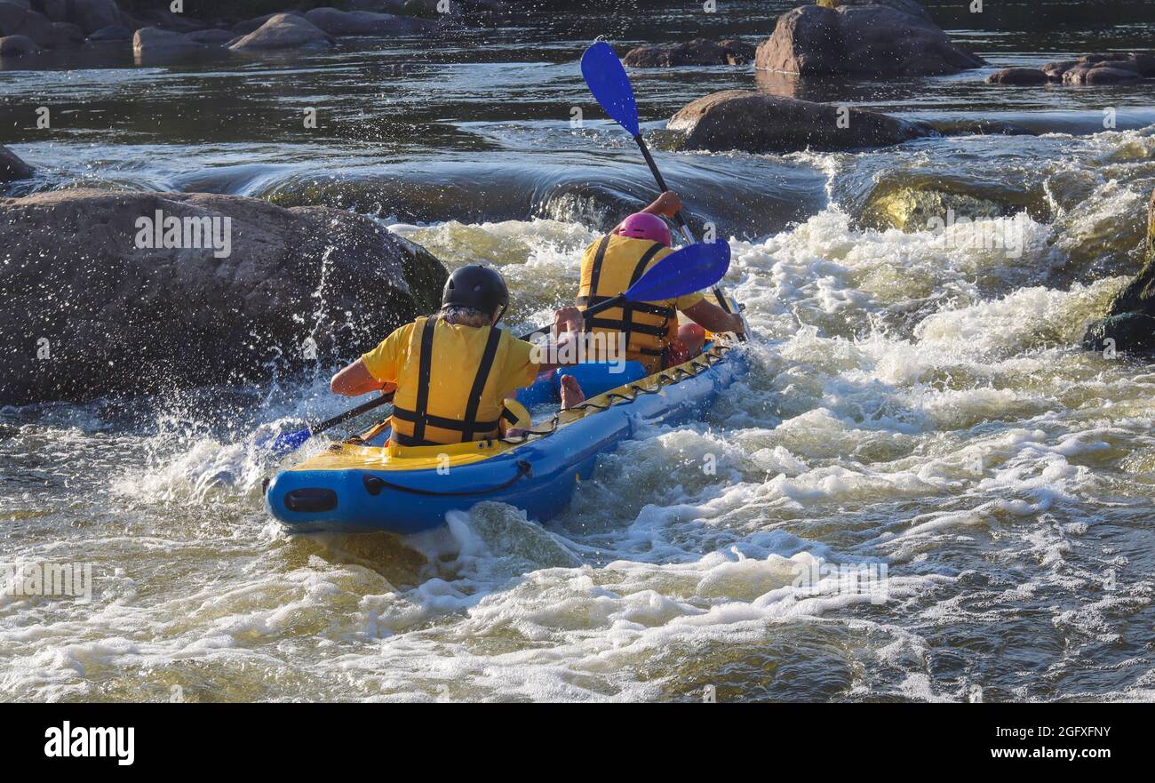Two man roving inflatable kayak on whitewater of mountain river ...