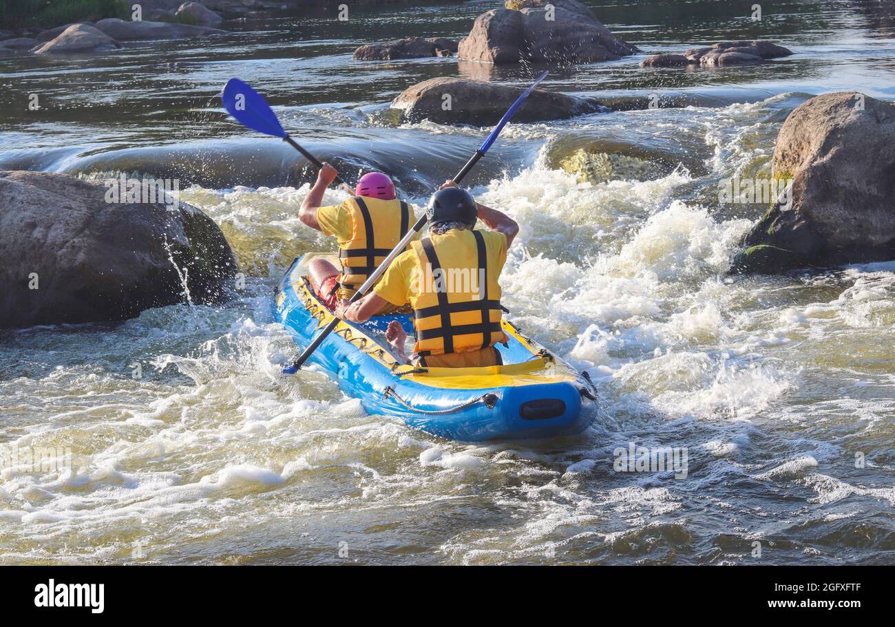 Two man roving inflatable kayak on whitewater of mountain river ...