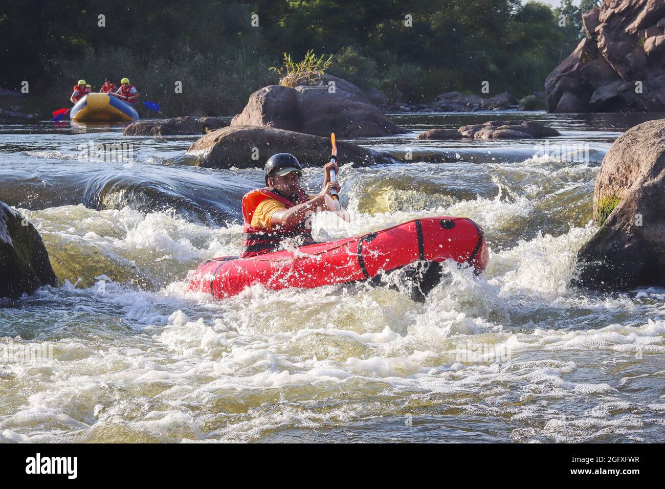 A man rowing inflatable packraft on whitewater of mountain river ...