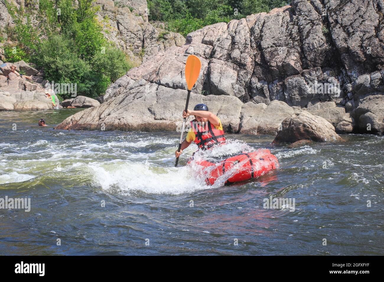 A man rowing inflatable packraft on whitewater of mountain river ...