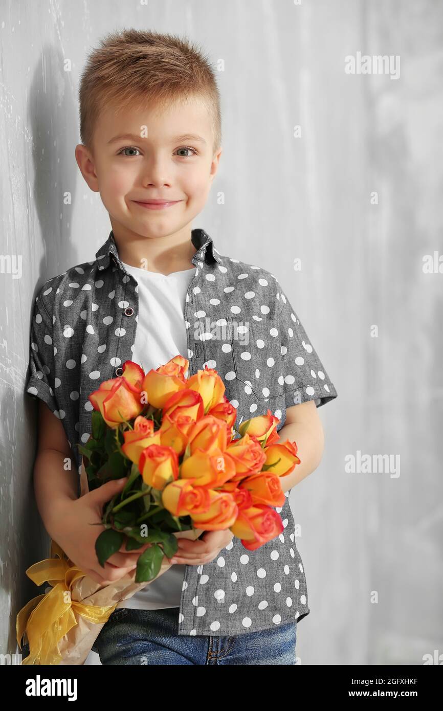 Cute boy with bouquet of beautiful flowers near grunge wall Stock Photo ...