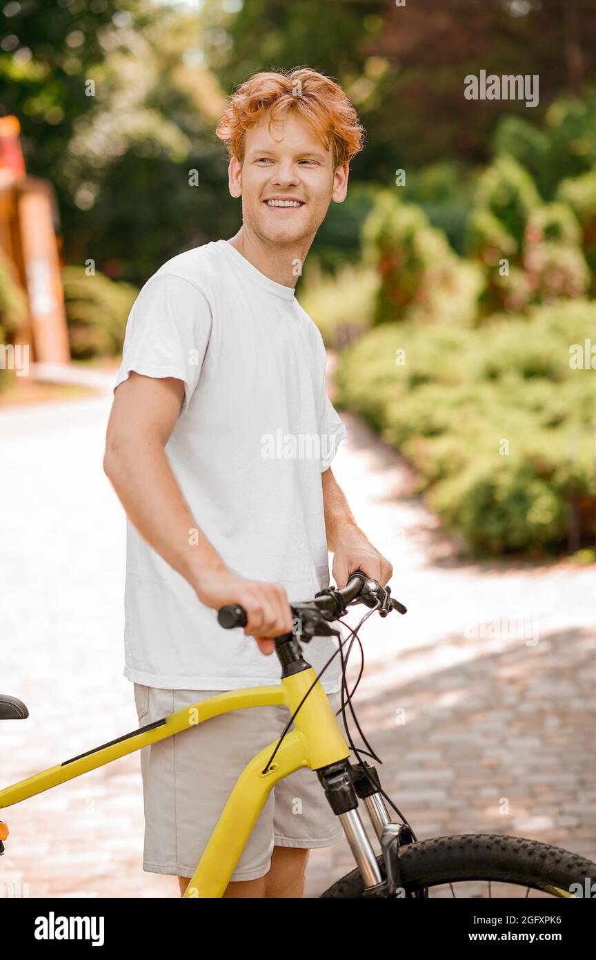 Contented male bike rider standing in a recreation park Stock Photo - Alamy