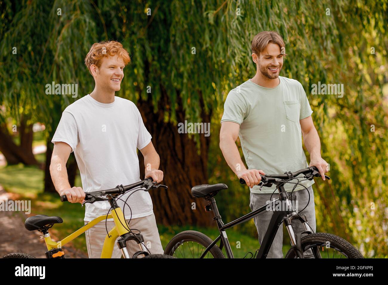 Two sporty friends with their bikes outdoors Stock Photo - Alamy