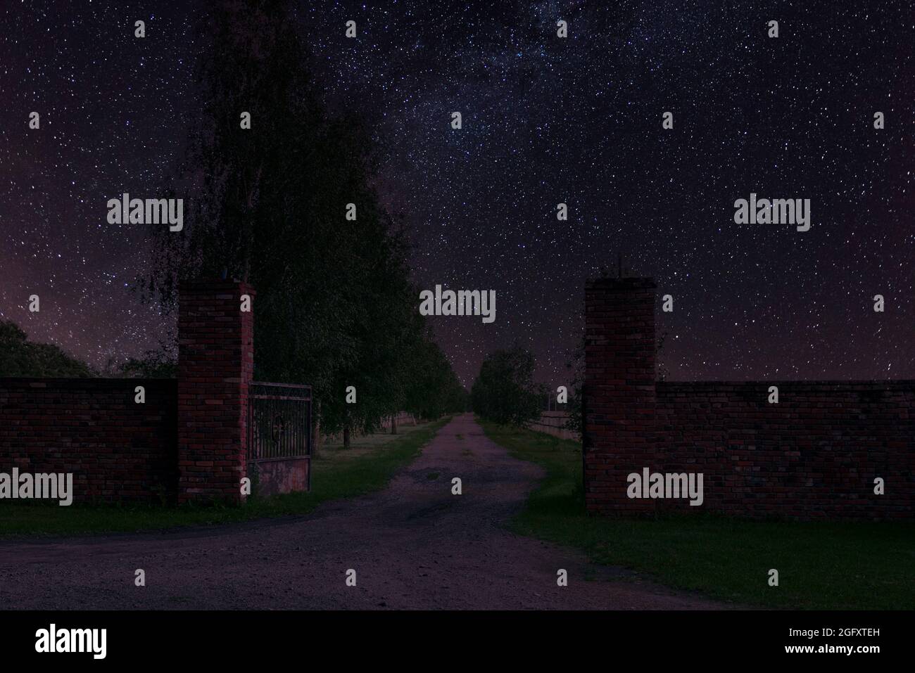 Gate and access road to the residence at night, shrouded in darkness ...