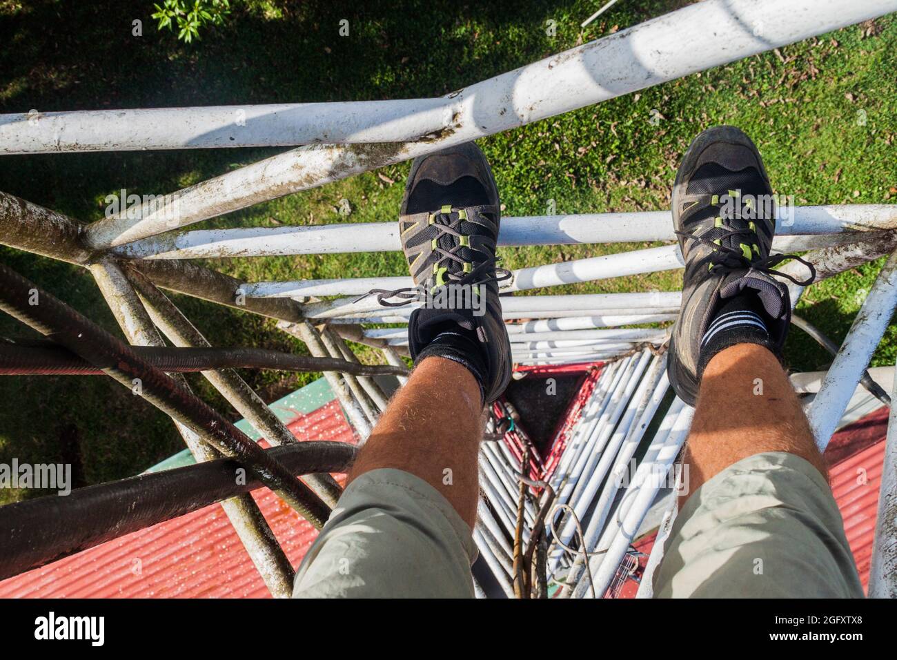 Person climbing a triangular guyed lattice mast near Santa Elena ...