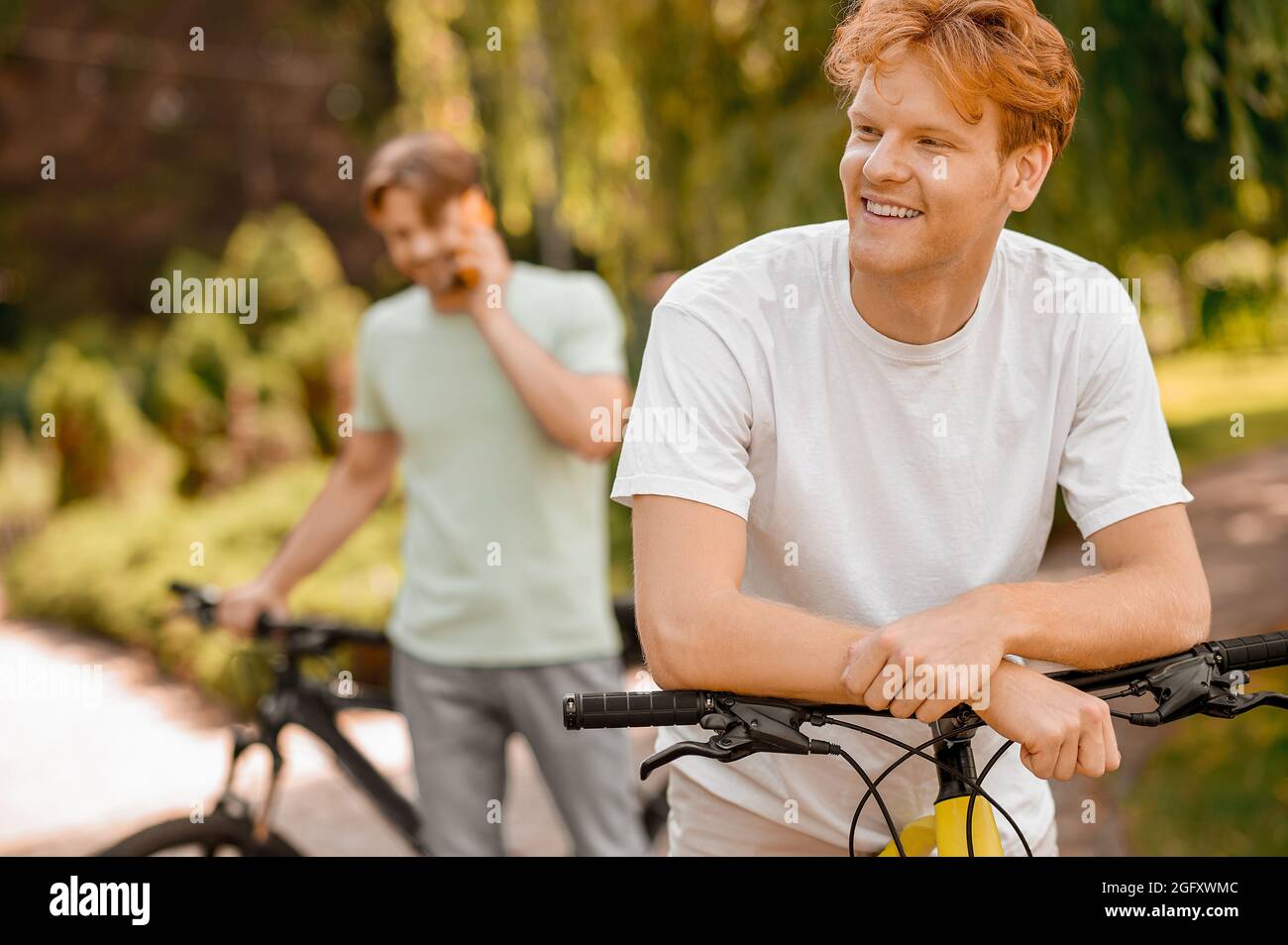 Two bicyclists standing in a local park Stock Photo - Alamy