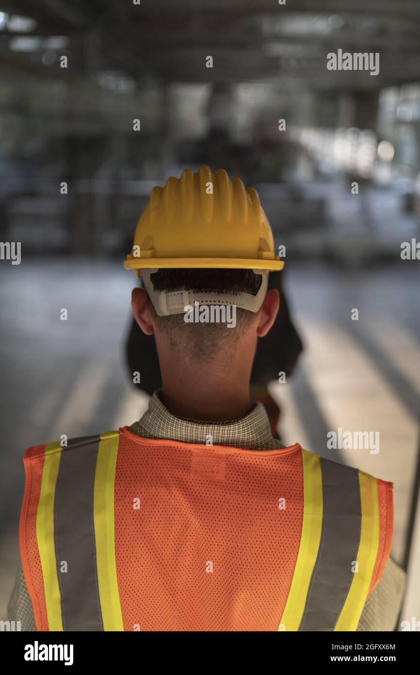 Vertical closeup of the worker standing in front of the windows and ...