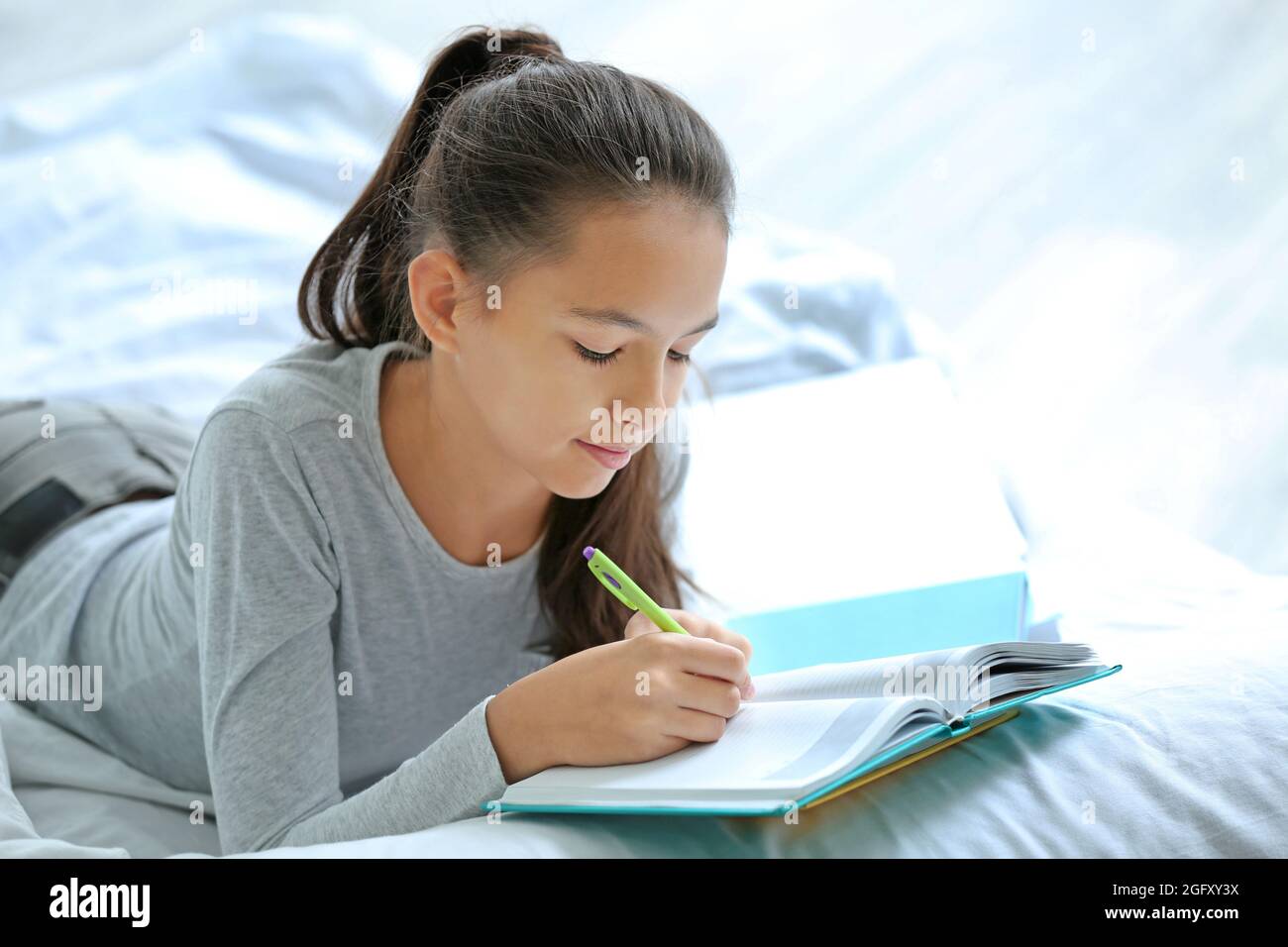 Cute girl doing lessons at home Stock Photo - Alamy