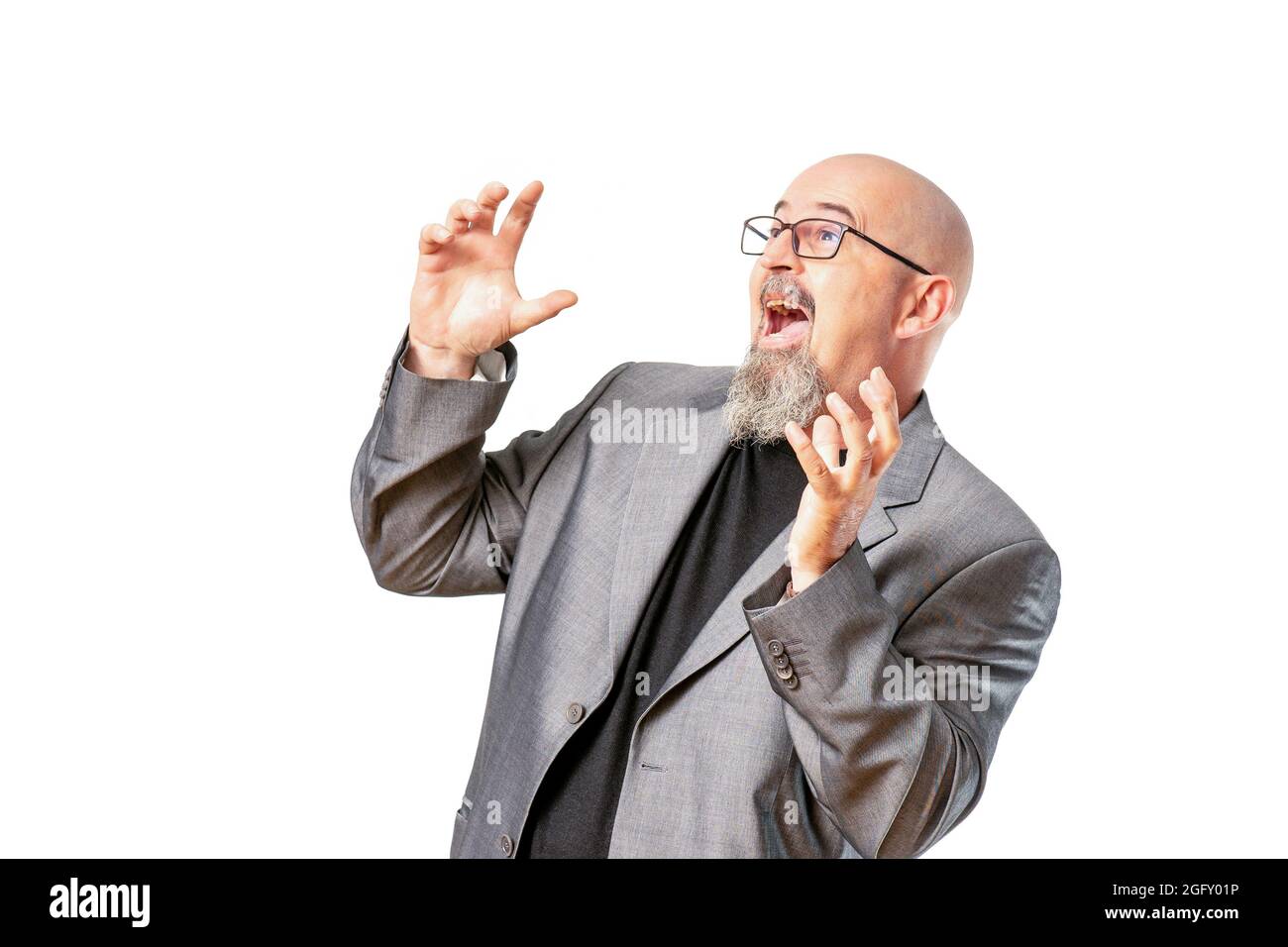Angry bearded bald male in a gray suit standing against an isolated ...