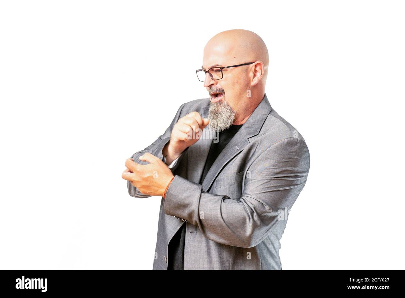 Angry bearded bald male in a gray suit standing against an isolated ...