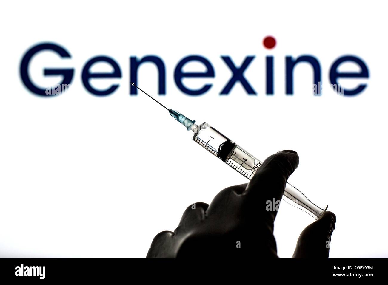 In this photo illustration, a close up of a hand holding a medical syringe in front of the ...