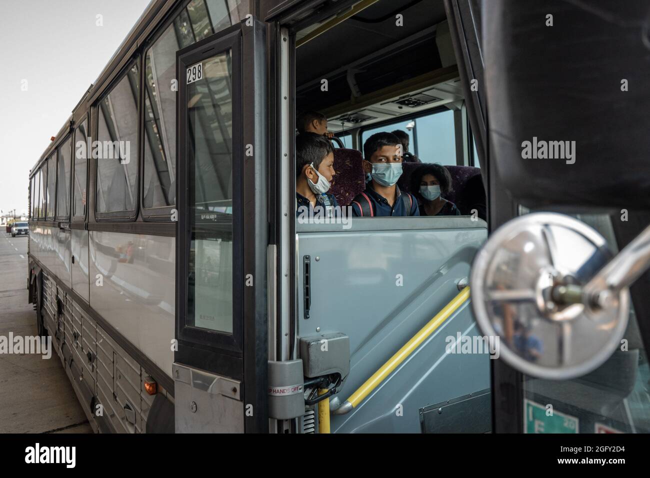 Arriving refugees evacuated from Kabul, Afghanistan board a bus that ...