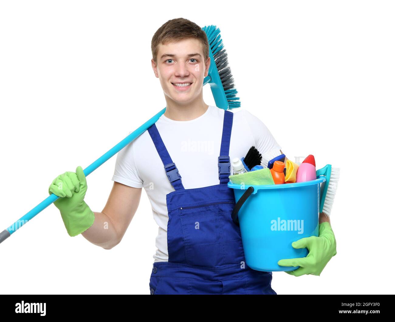 Young man holding cleaning equipment and supplies on white background ...