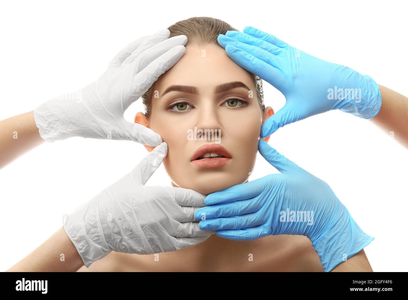 Hands touching female face on white background. Plastic surgery concept ...