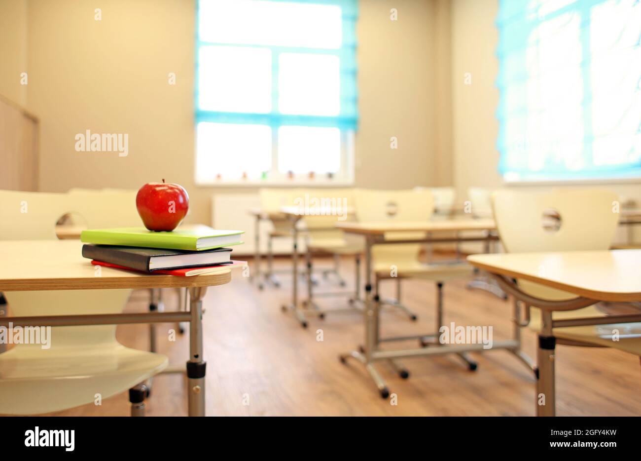 Stack of books and apple on desk at classroom Stock Photo - Alamy