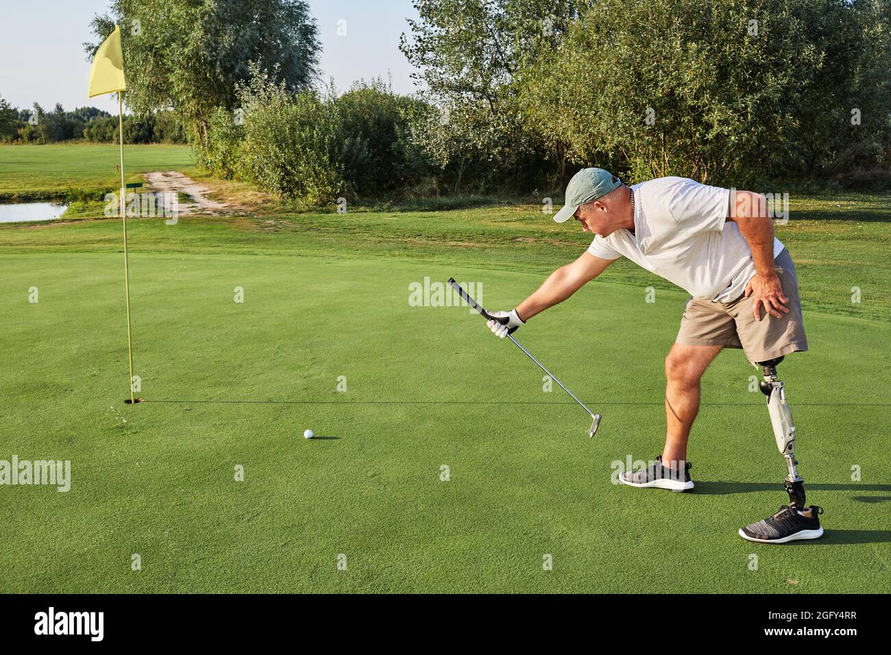 Professional golfer with a artificial leg during playing golf takes aim ...