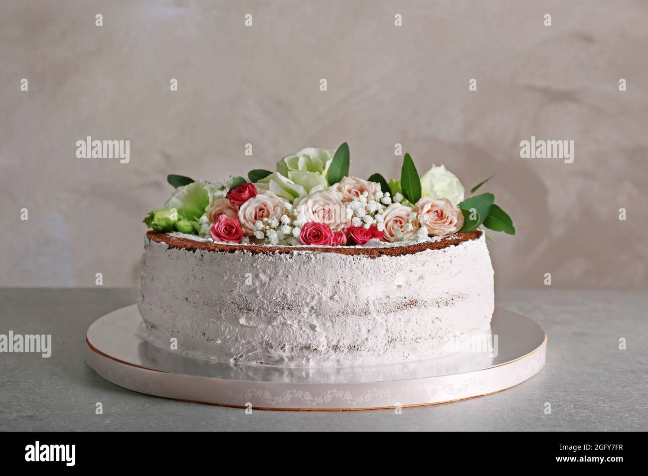 Delicious wedding cake on table and grey textured background Stock ...