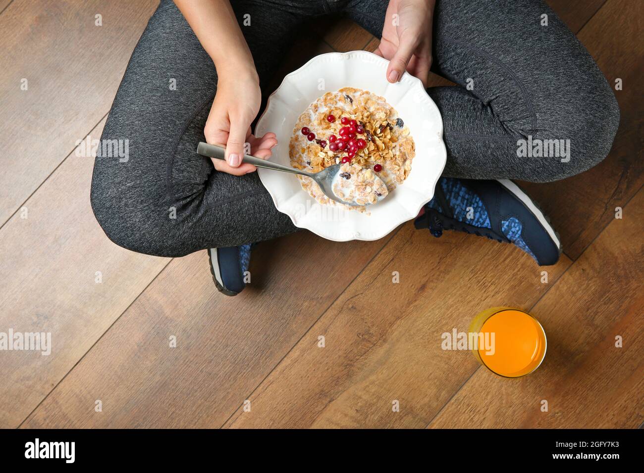 Woman sitting on the floor with healthy breakfast Stock Photo - Alamy