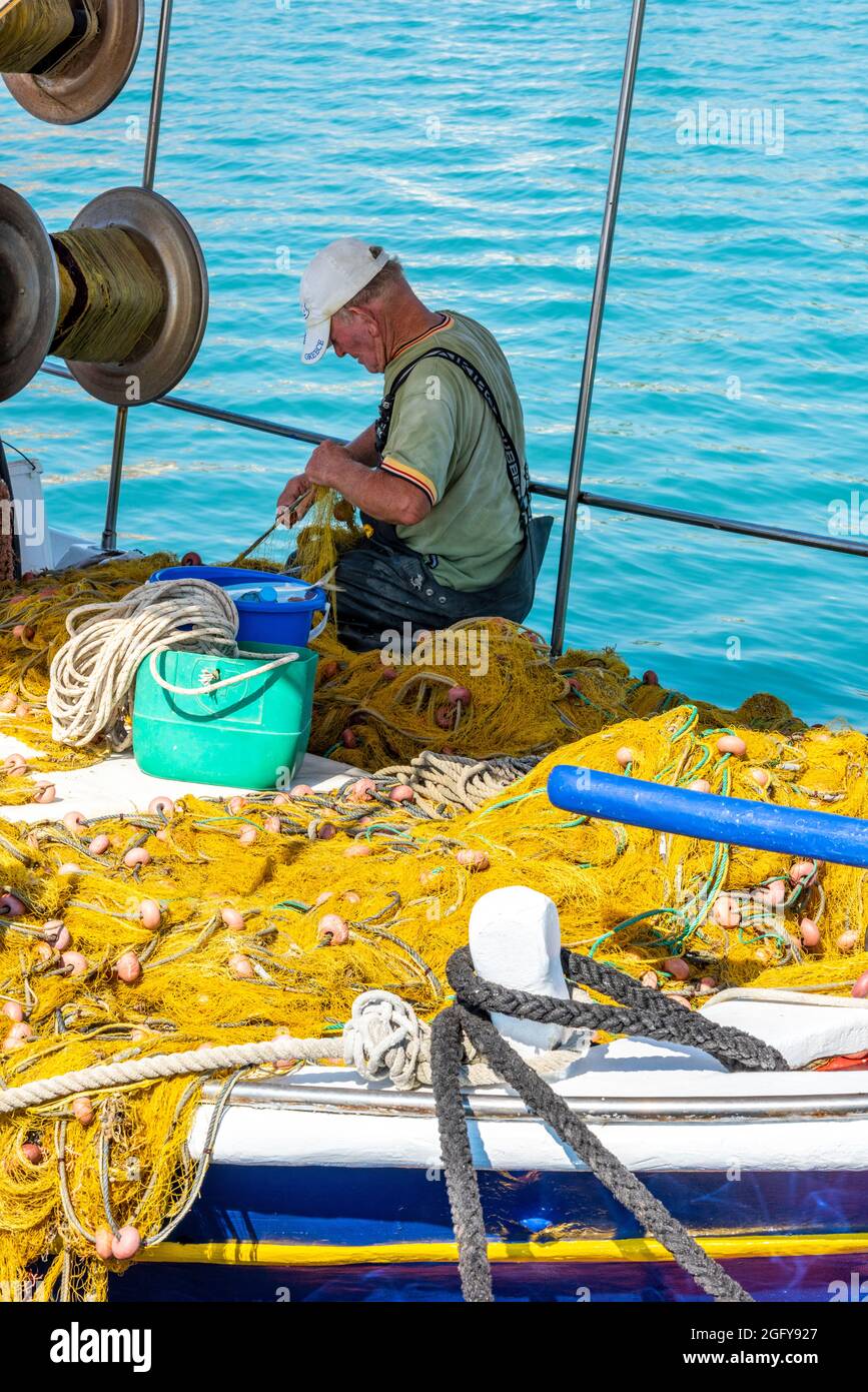greek fisherman mending nets on zante, fisherman in greece on boat ...