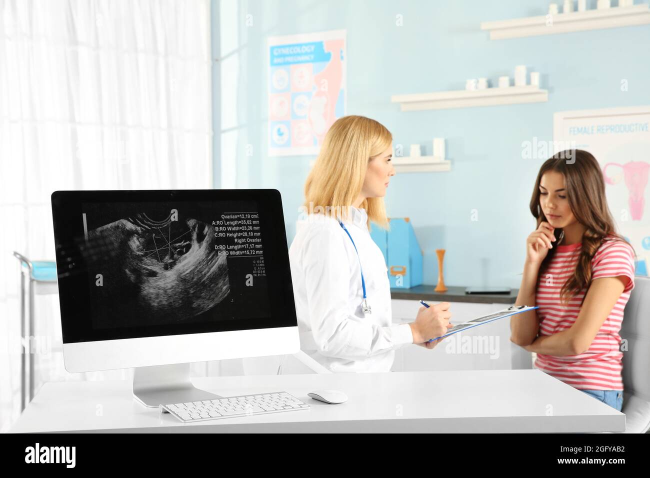 Computer with ultrasound scan with doctor and patient on background ...
