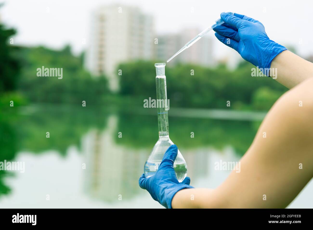 Sampling from open water. A scientist or biologist takes a sample of ...