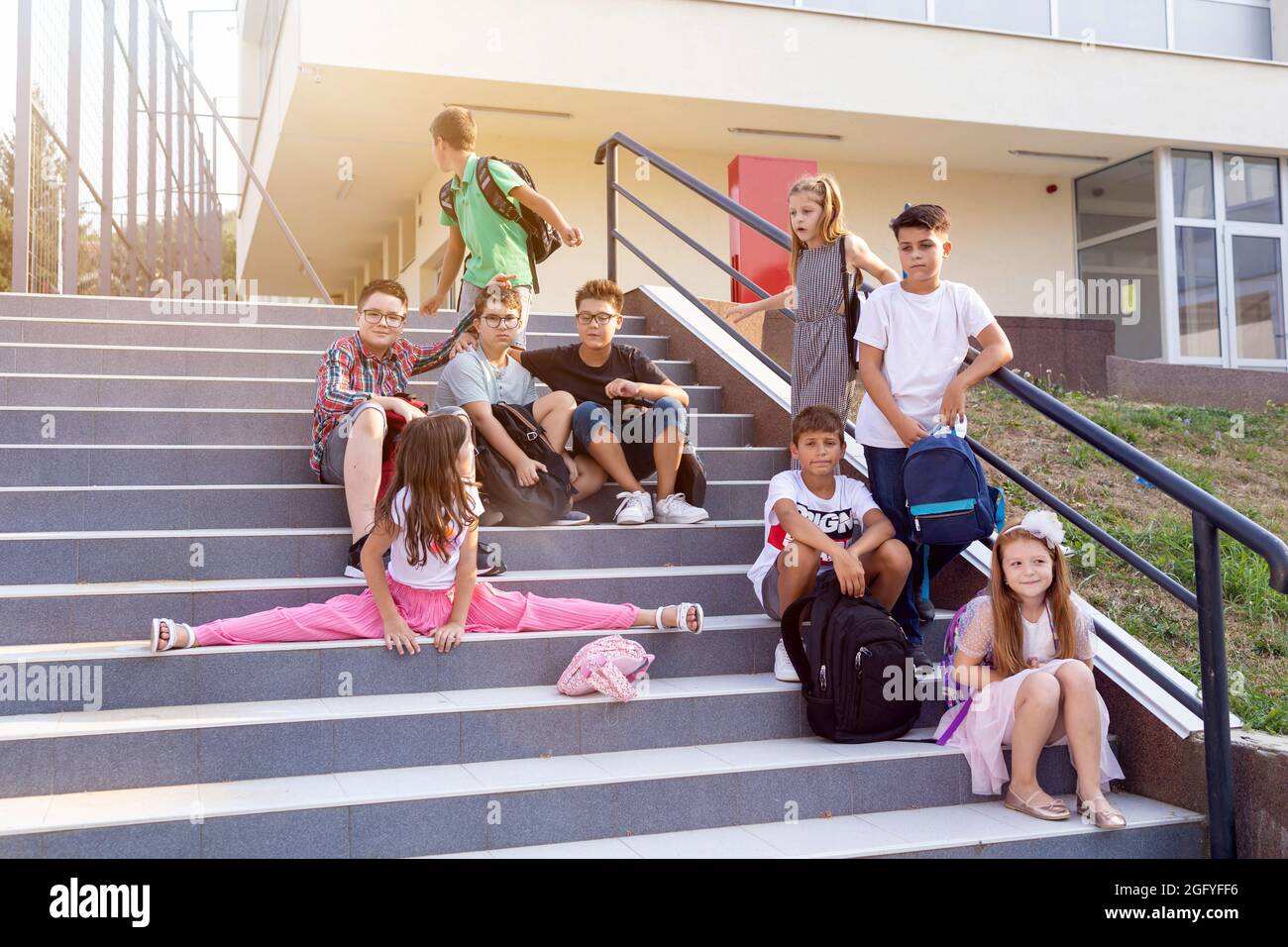 Group of elementary school kids having fun before classes, sitting on ...