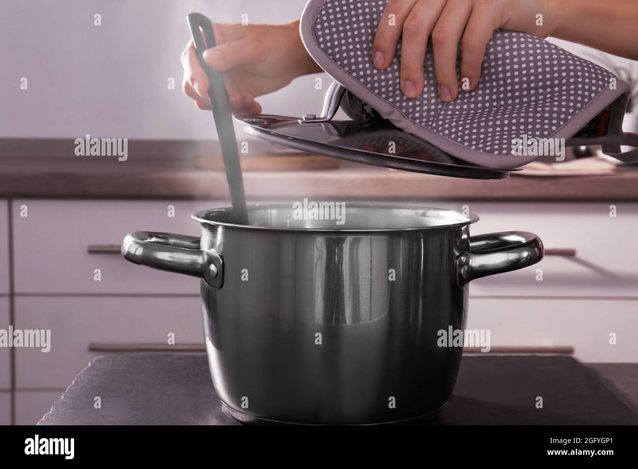 Woman hand mixing food in metal pan in kitchen Stock Photo - Alamy