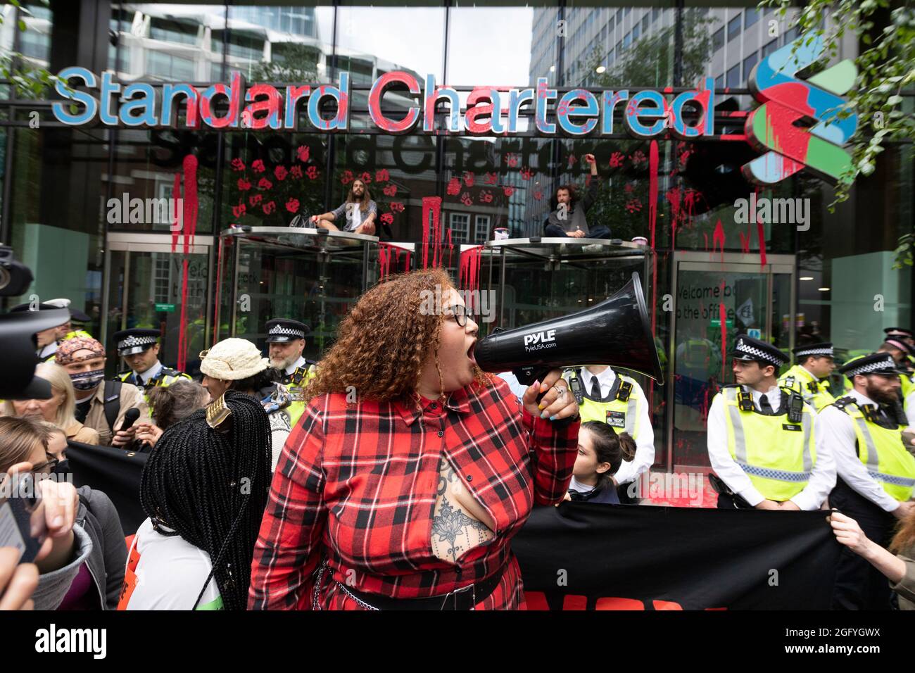 27/08/2021. London, UK. Protesters paint the Standard Chartered bank ...