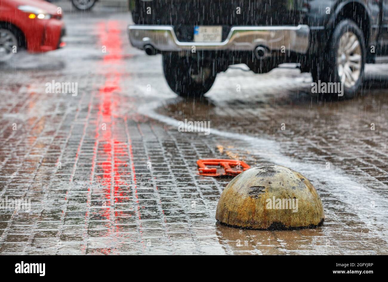 Heavy rain on a paved parking lot and intersection and red light ...