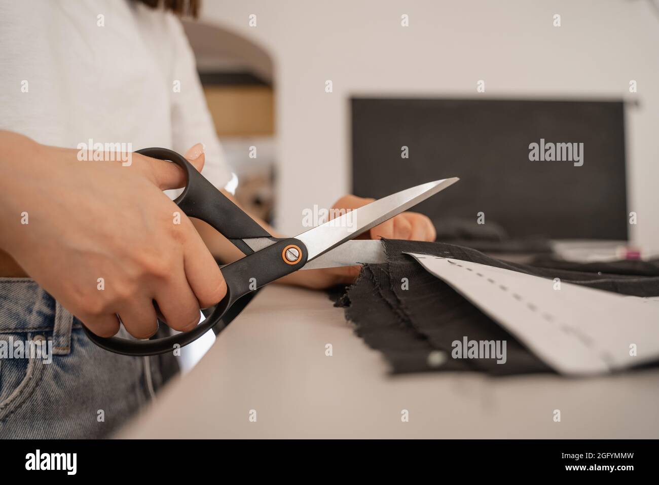 Cropped view of designer cutting cloth with sewing pattern Stock Photo ...