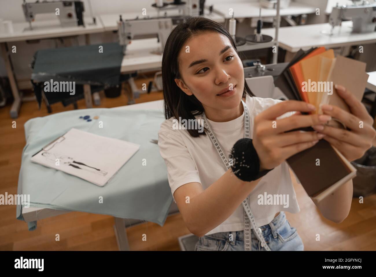 Asian designer holding blurred color swatches in atelier Stock Photo ...