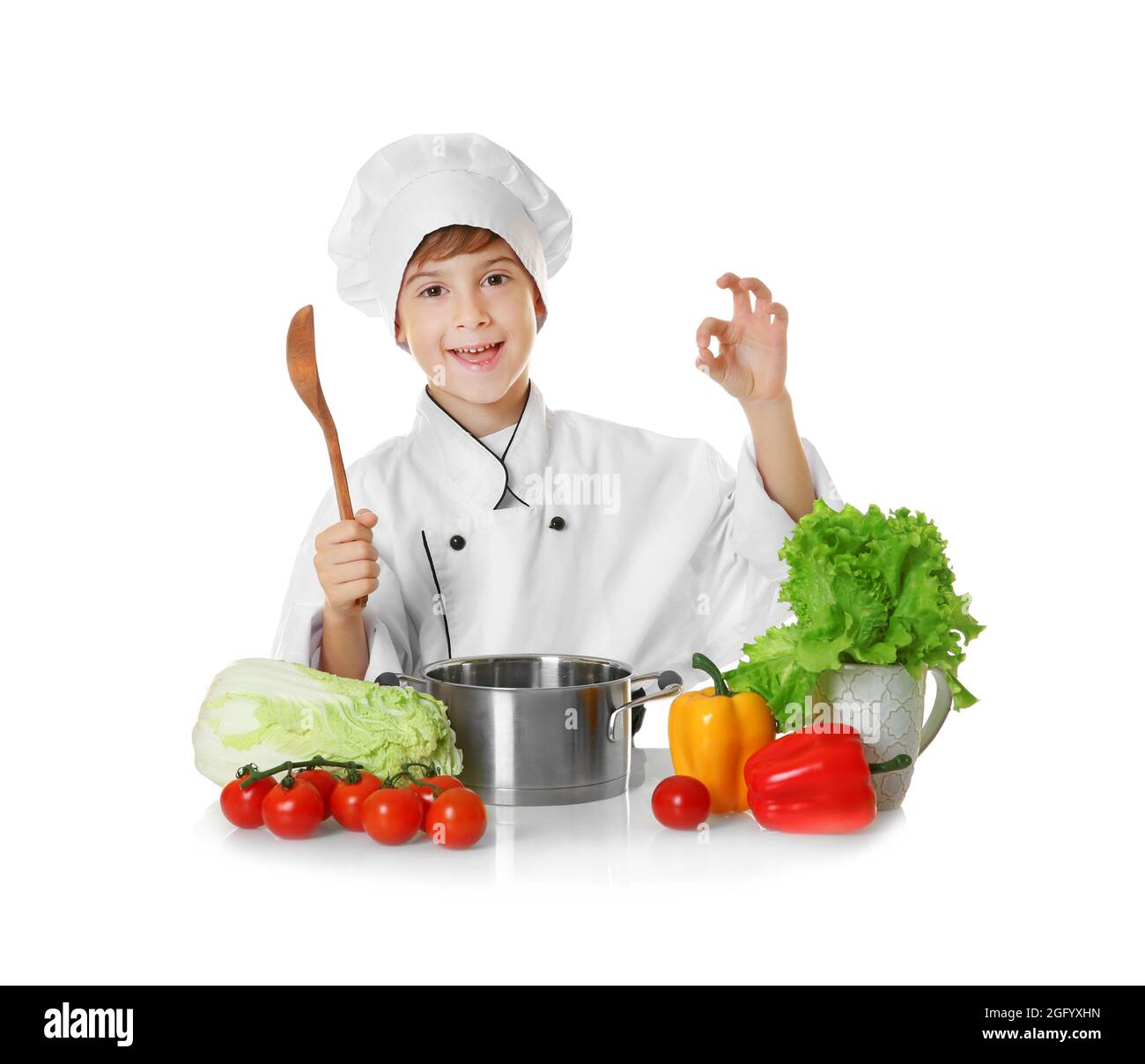 Cute boy in chef uniform preparing tasty soup, on white background ...