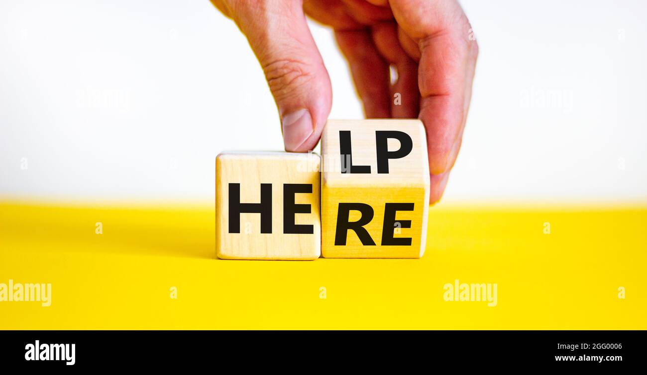 Help is here symbol. Businessman turns a cube and changes the word help ...