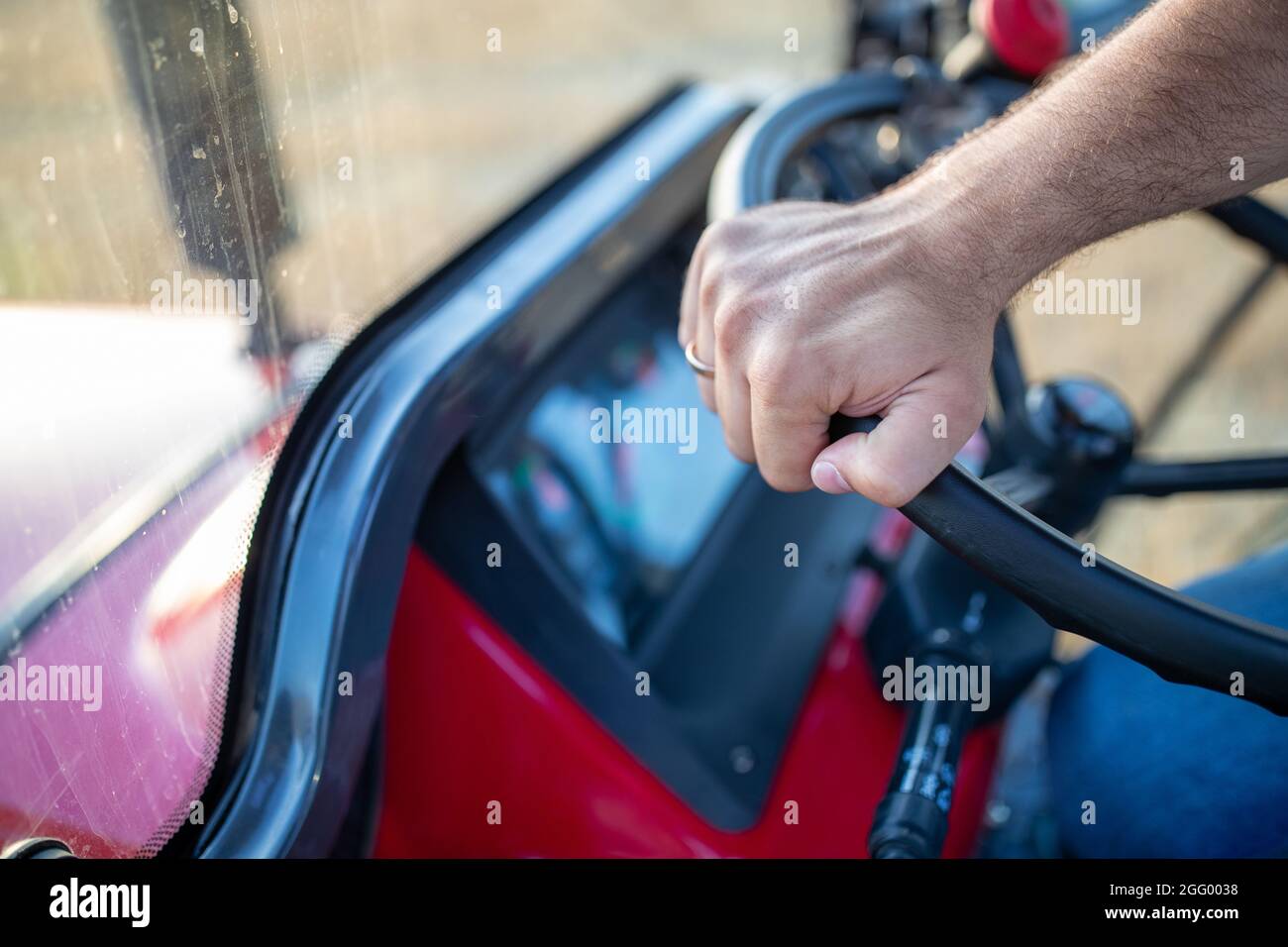 Close up of farmer's hand on steering wheel of tractor in field Stock ...