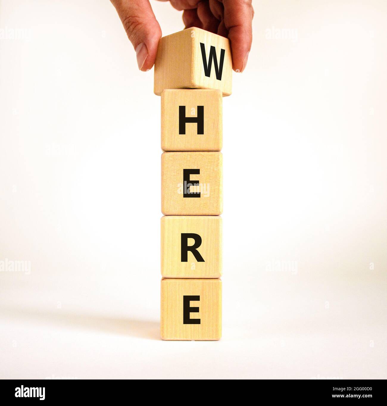 Where or here symbol. Businessman turns a wooden cube, changes the word ...