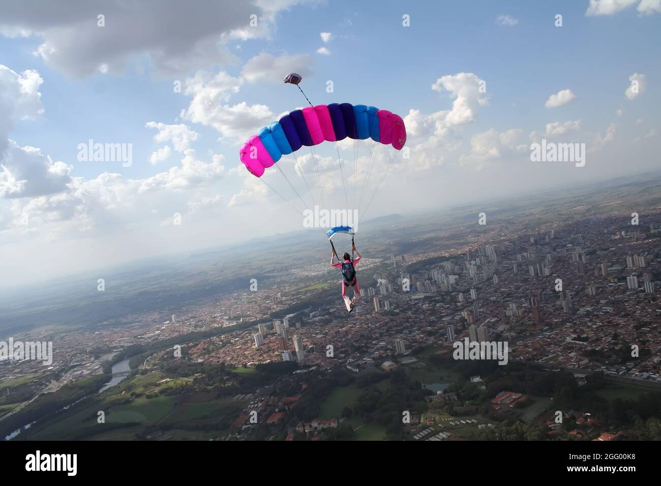 Skydiver flying her parachute over the city Stock Photo - Alamy