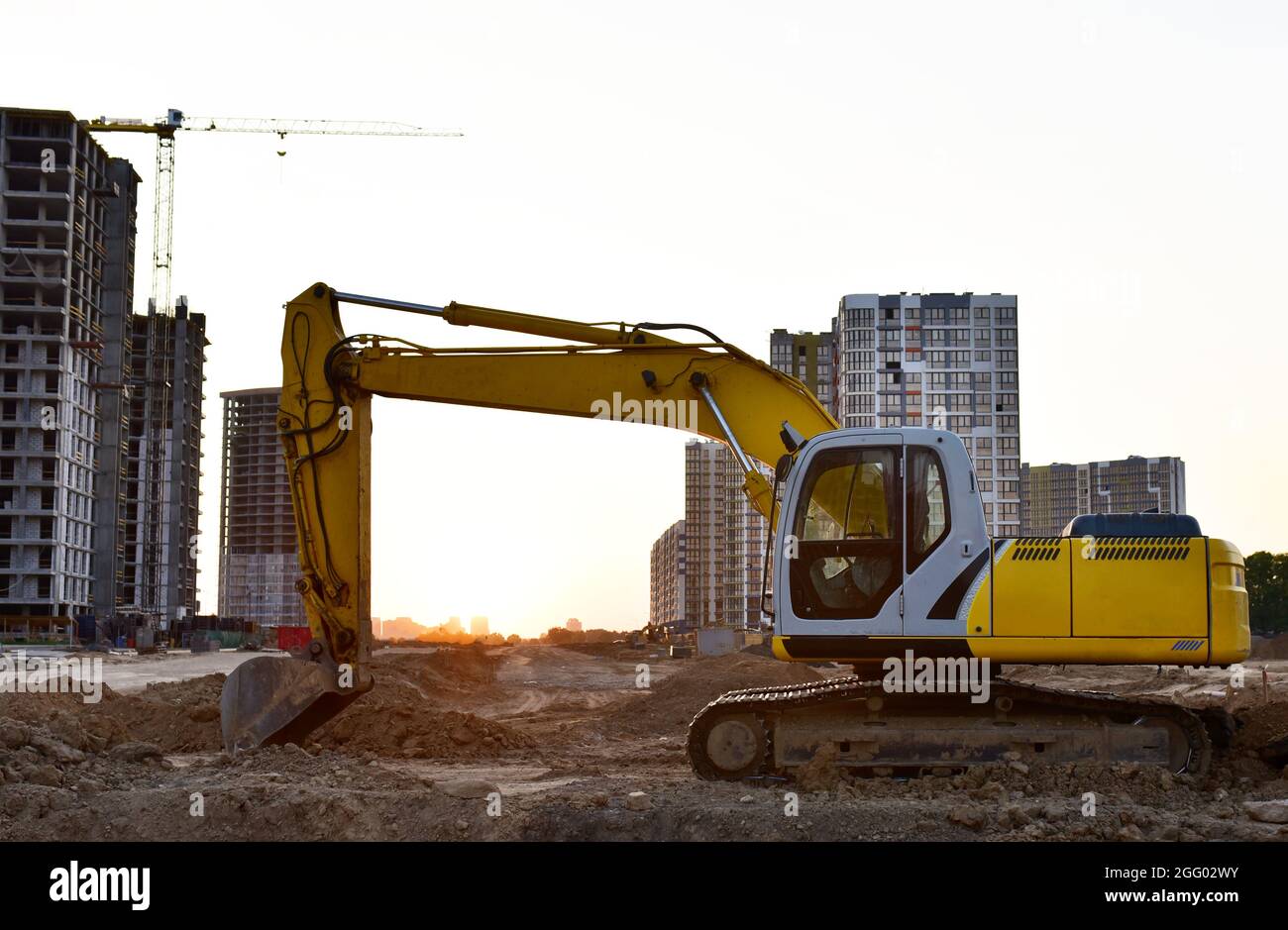 Excavator on earthworks at construction site on sunset background ...