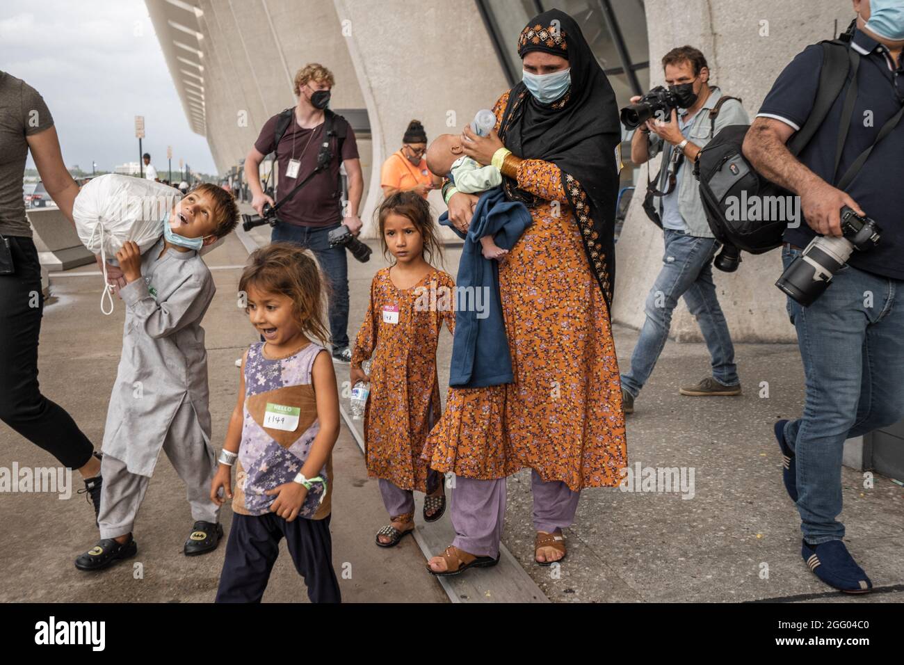 Arriving refugees evacuated from Kabul, Afghanistan board a bus that ...