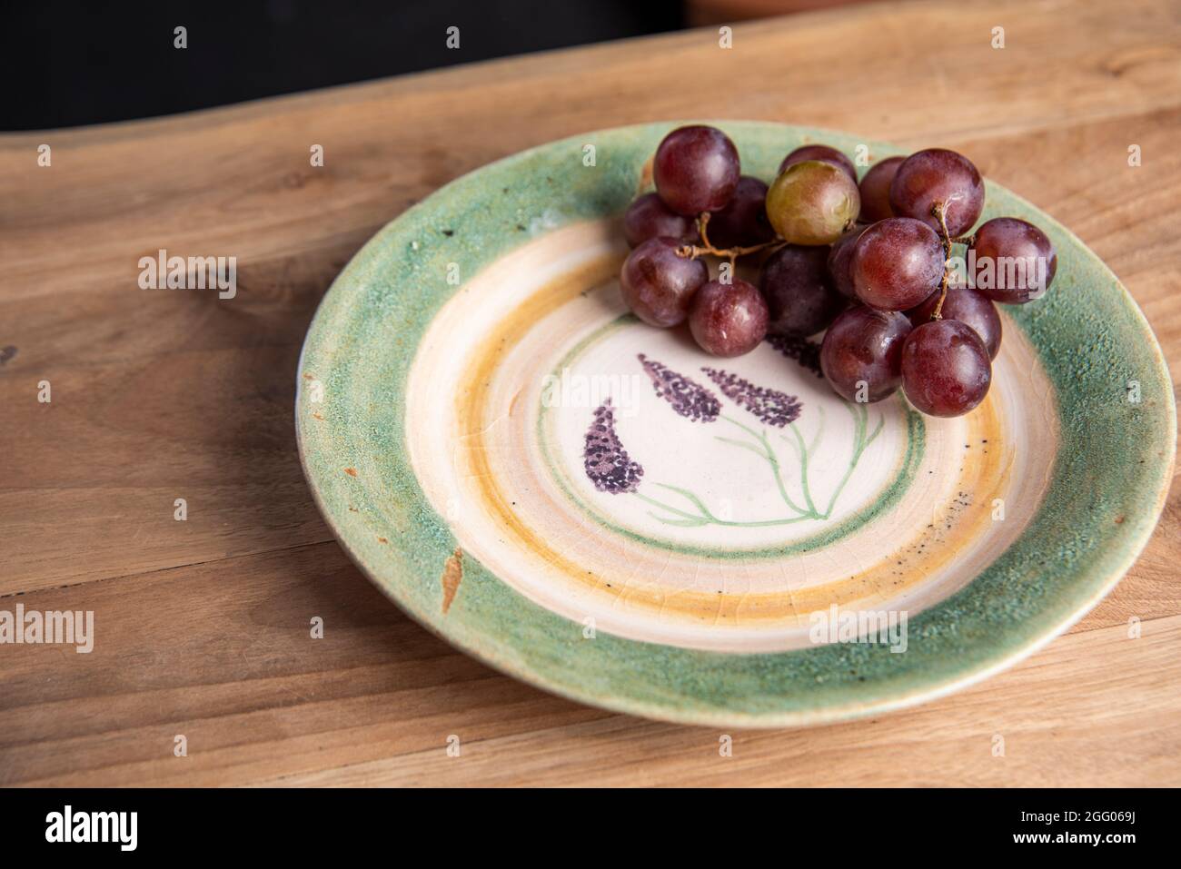 piece of grapes in a ceramic design plate Stock Photo - Alamy