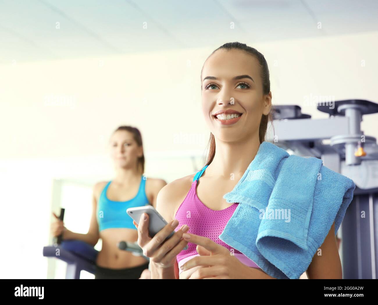 Young woman with phone in gym Stock Photo - Alamy