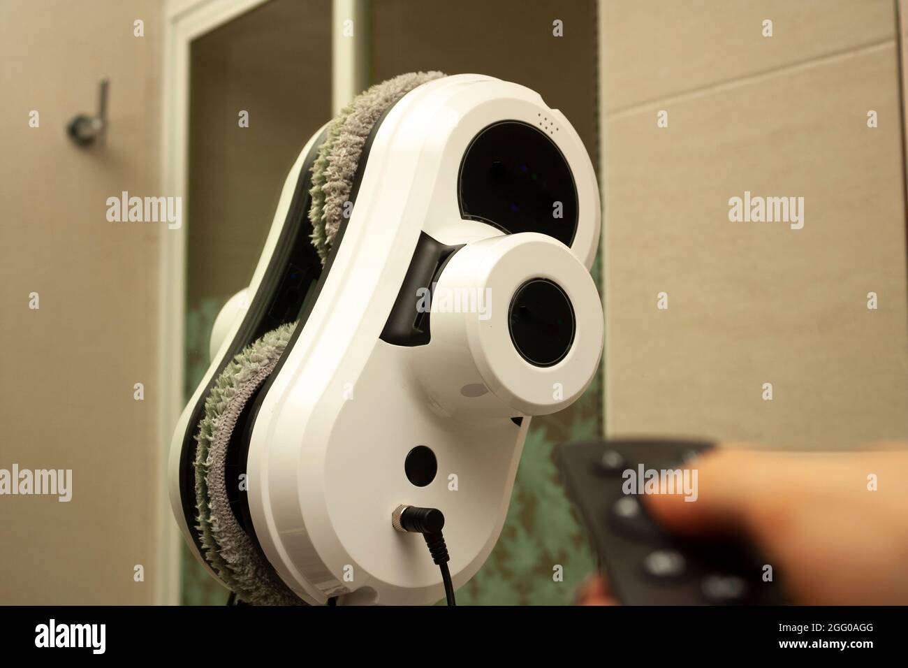 Working at home cleaning mirror inside bathroom in Mexico City, woman ...