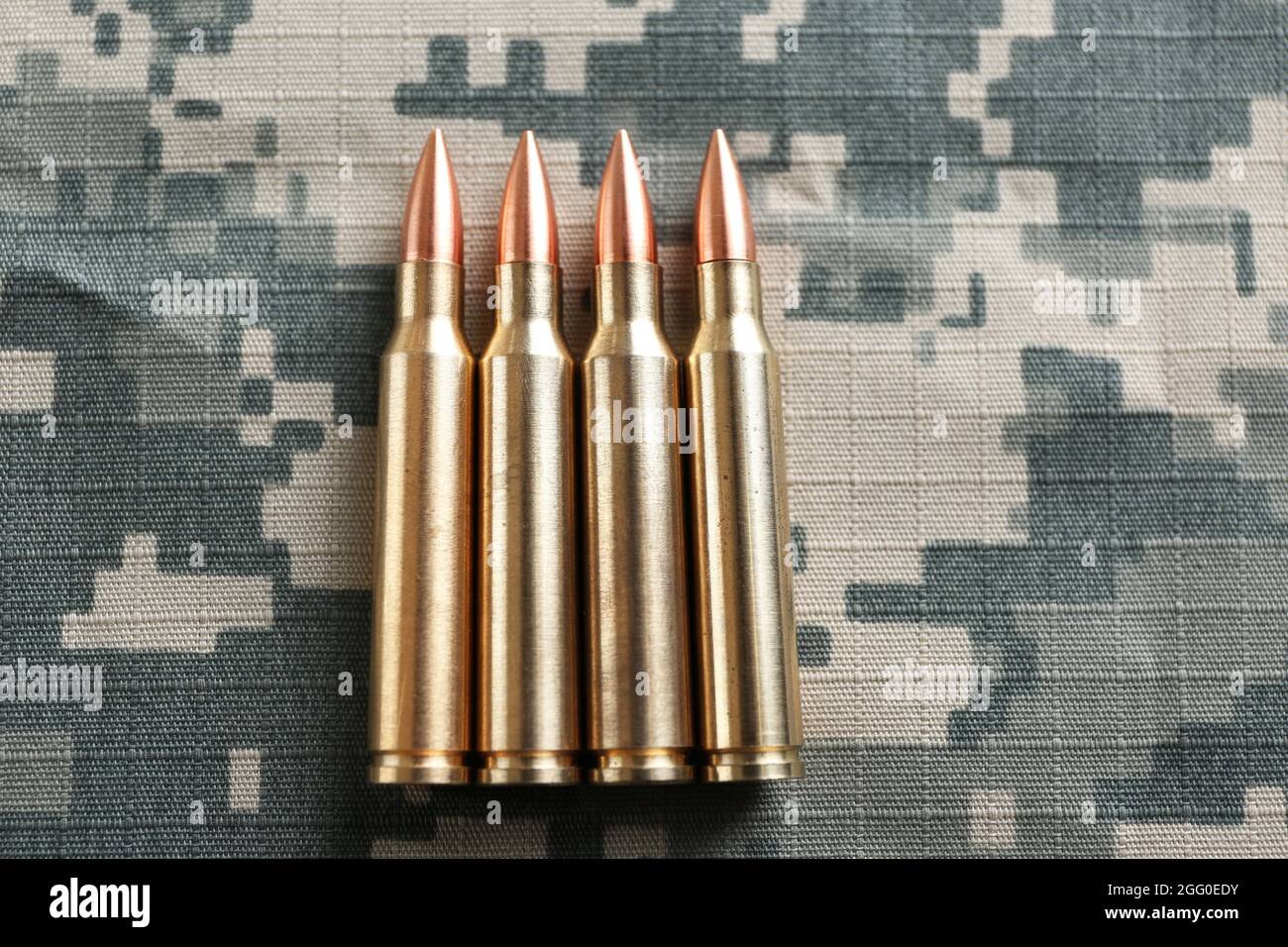 Bullets on camouflage background Stock Photo - Alamy