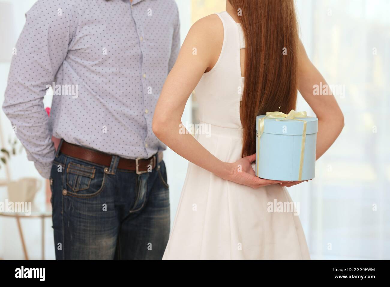 Cute young couple hiding presents for each other, closeup Stock Photo ...