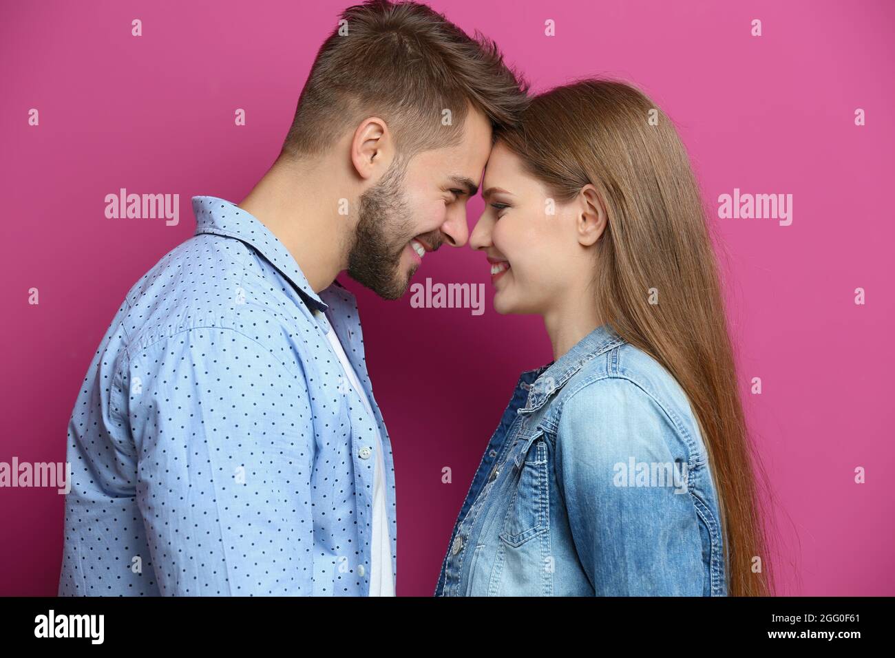 Cute young couple on color background Stock Photo - Alamy