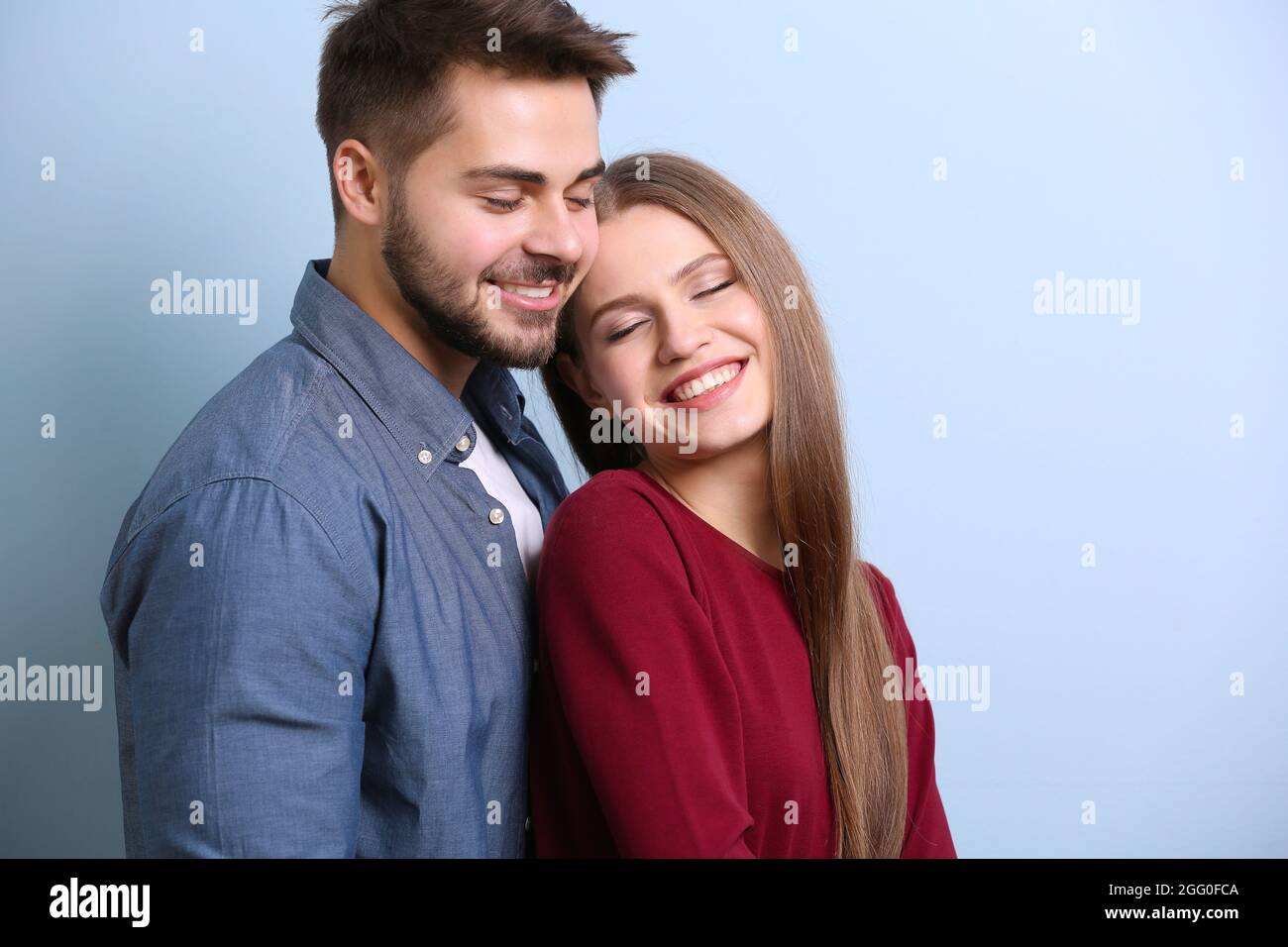 Cute young couple on color background Stock Photo - Alamy