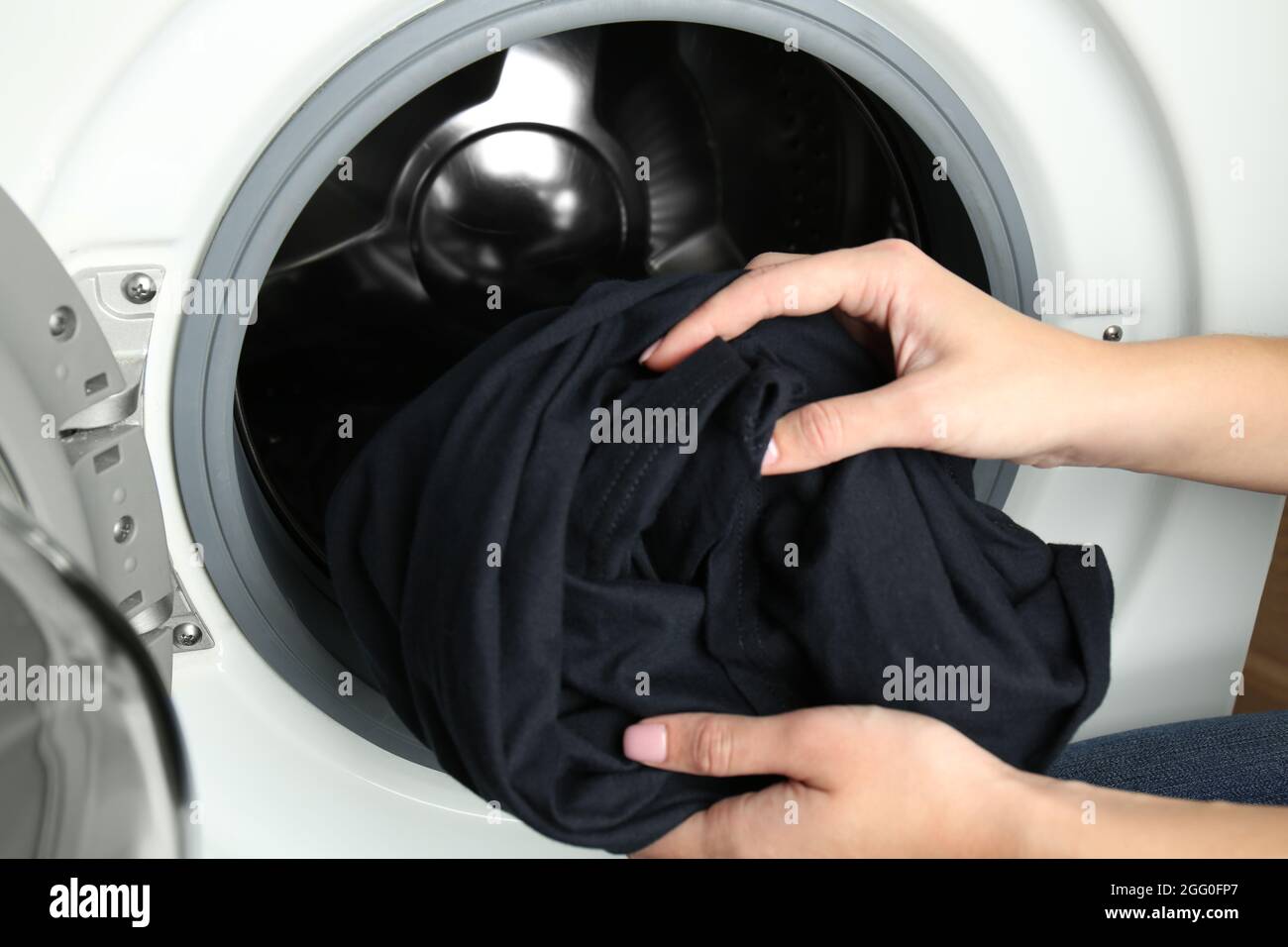 Female hands getting out clean clothes from washing machine Stock Photo ...