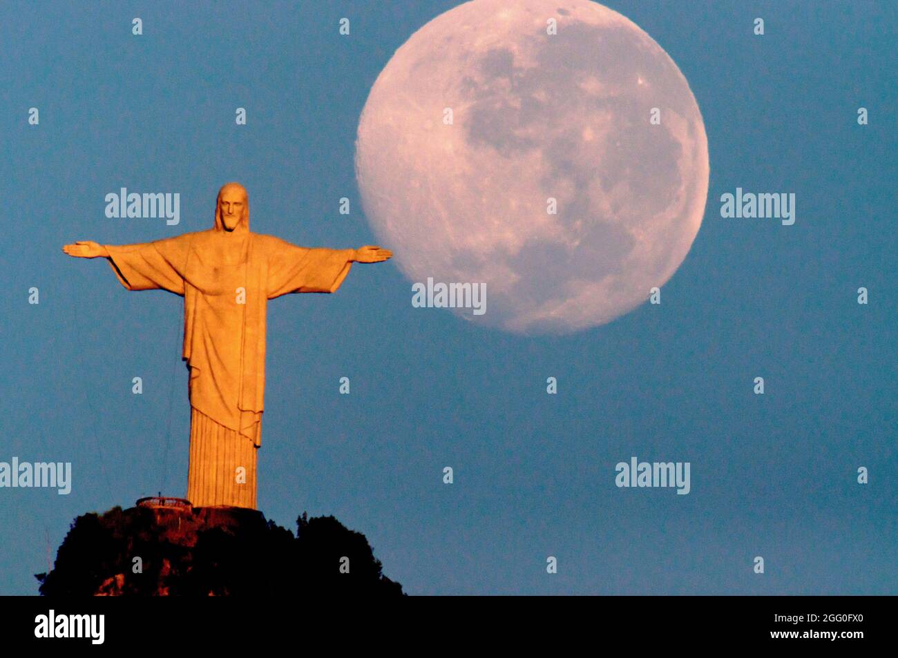 Christ the Redeemer early in the morning with the big moon in the ...