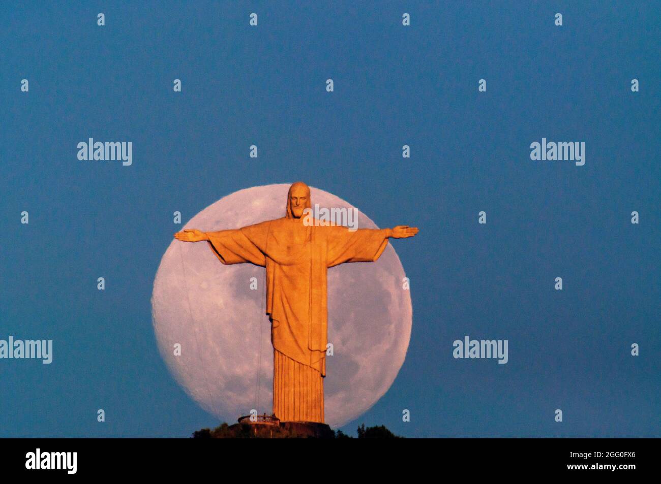 Christ the Redeemer early in the morning with the big moon in the ...