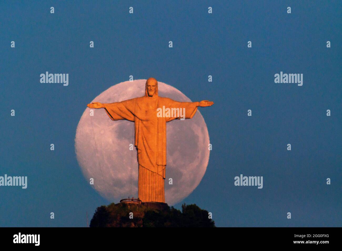 Christ the Redeemer early in the morning with the big moon in the ...
